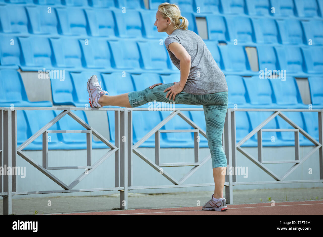 leg stretching woman runner before running training at stadium Stock ...