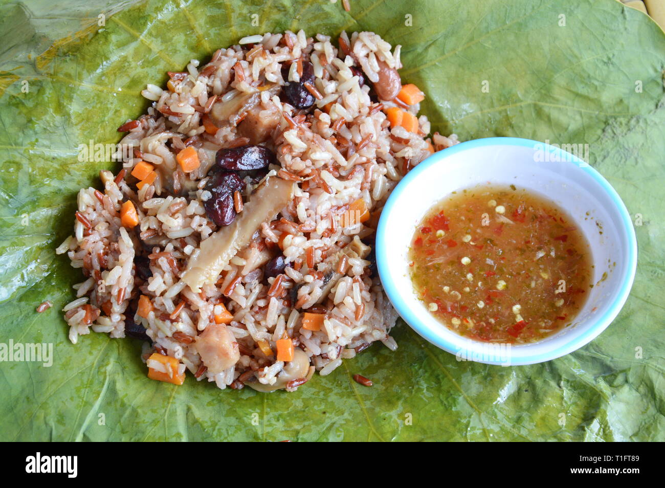steamed rice and whole grain wrapped in lotus leaf with spicy sauce ...