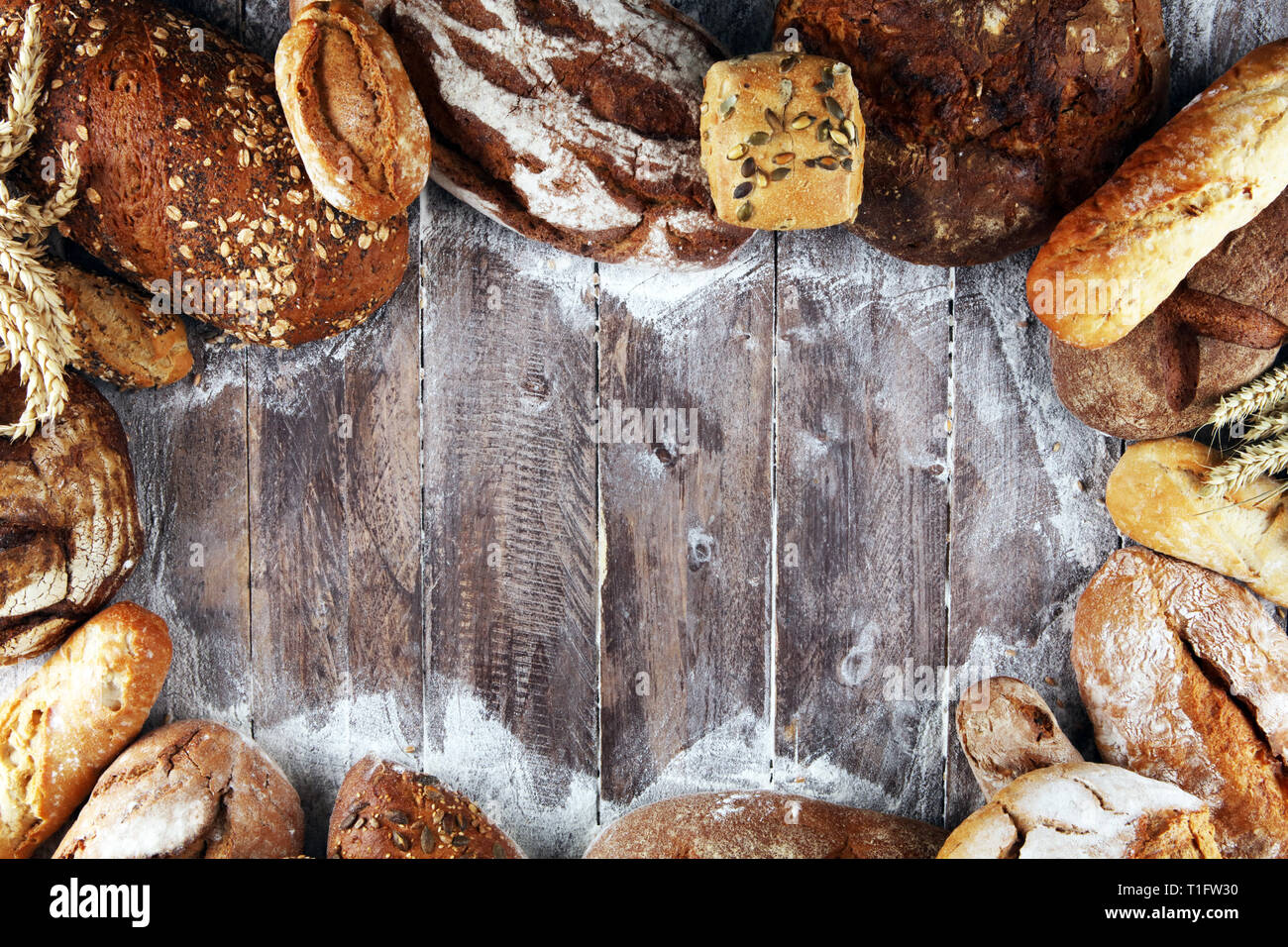 Different kinds of bread and bread rolls on board from above. Kitchen ...