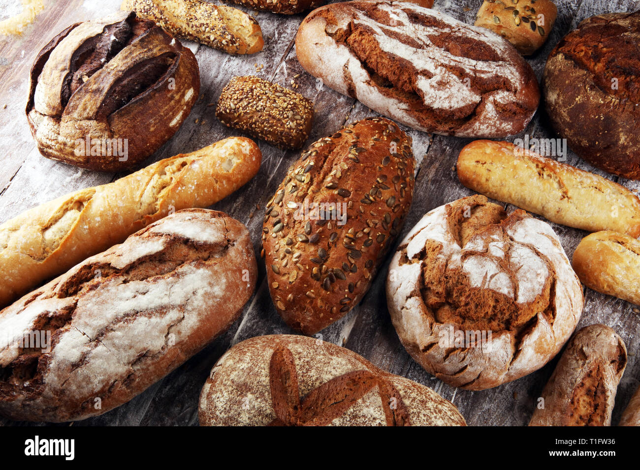 Different kinds of bread and bread rolls on board from above. Kitchen ...