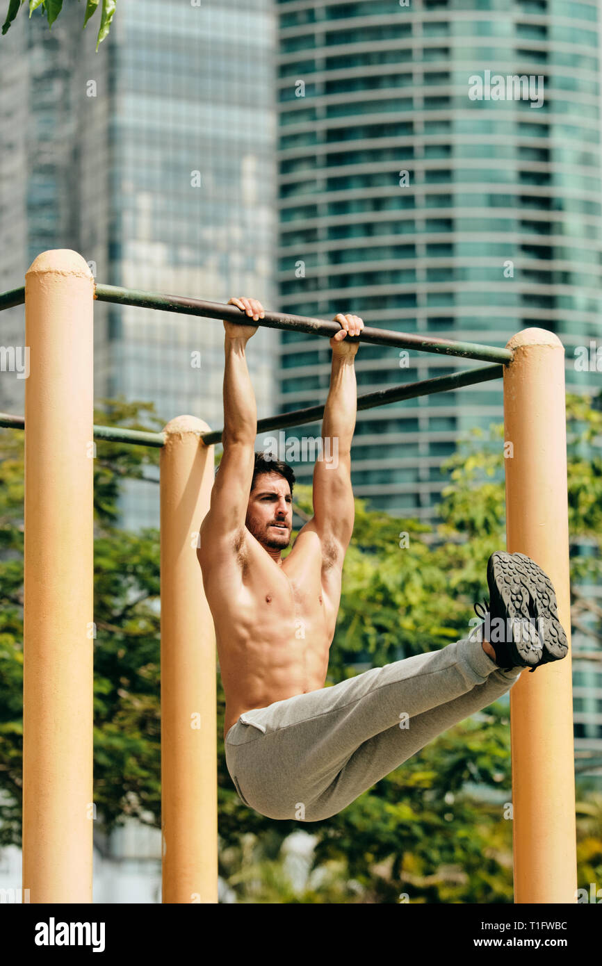 Beautiful young man training and working out in park. Handsome hispanic ...