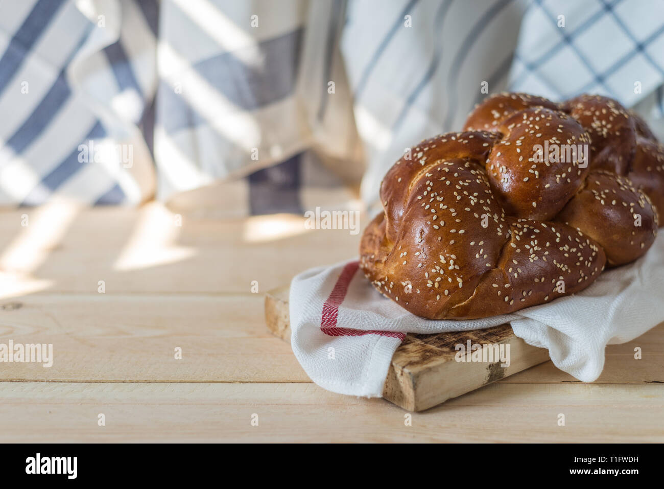 Challah bread on a wood plate on wooden table / white background with ...