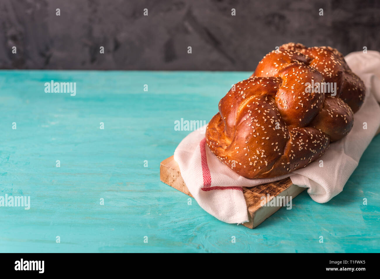 Challa bread , traditional jewish bread , on wooden plate and blue ...