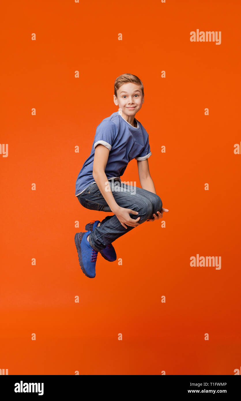 Cheerful school boy jumping in bomb style Stock Photo - Alamy