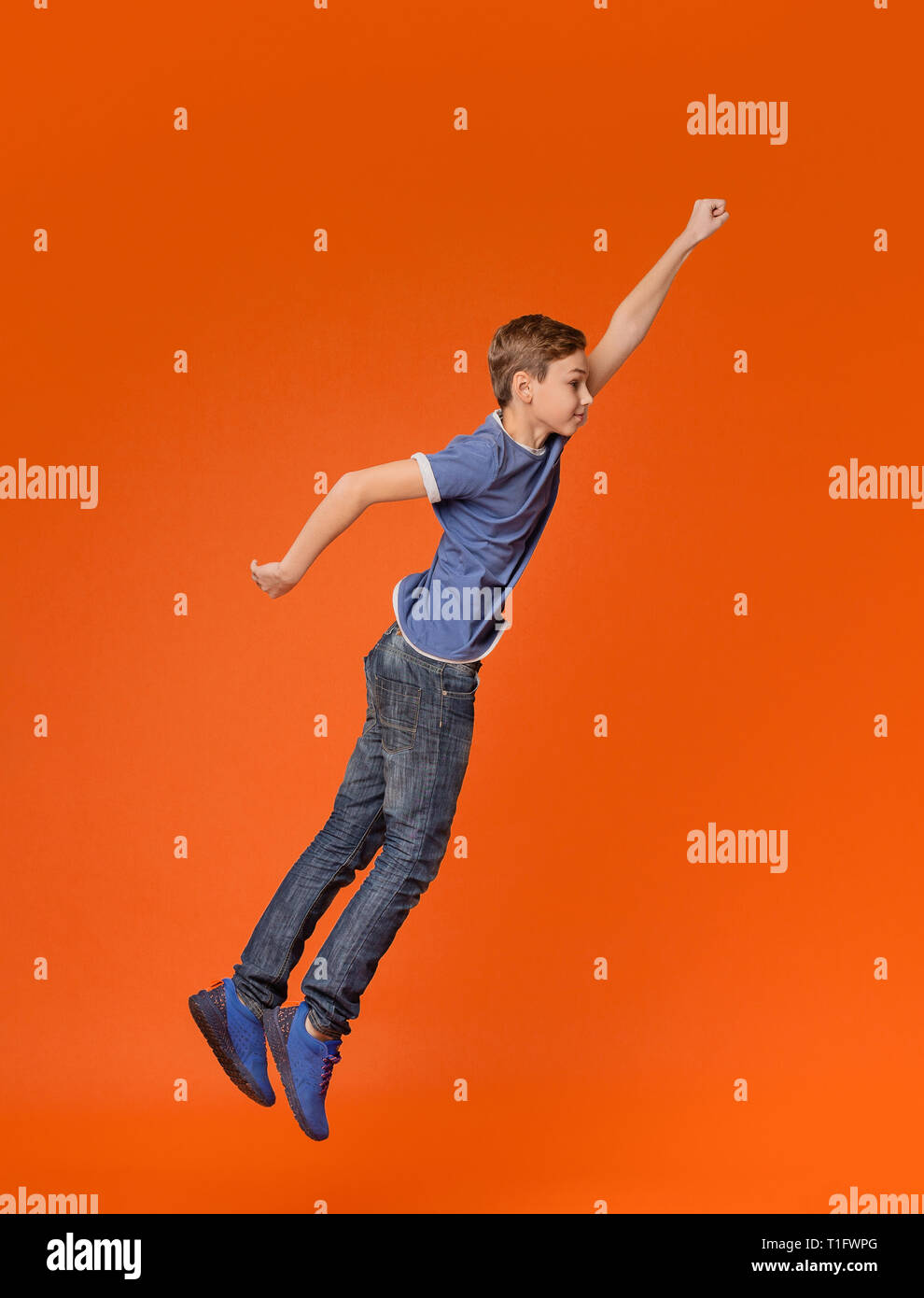 Little boy jumping with raised fist like superhero Stock Photo - Alamy