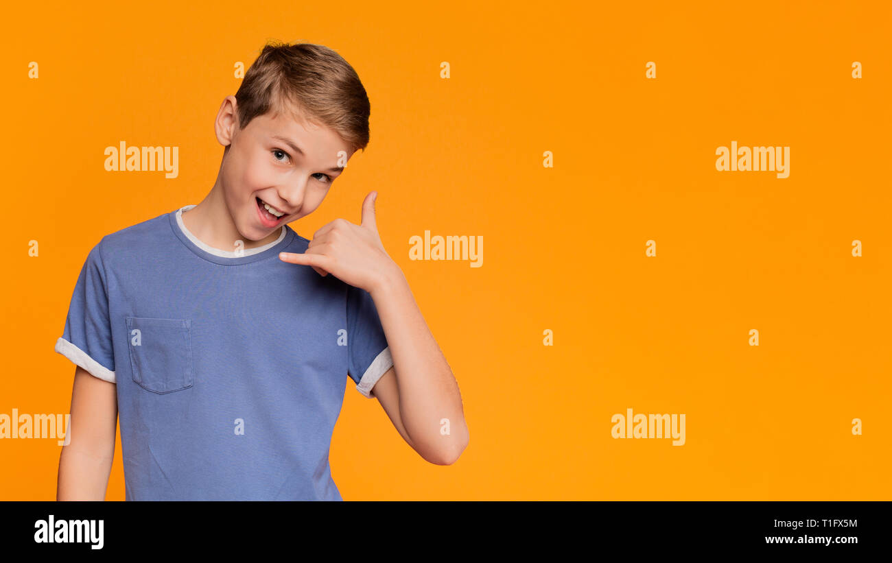 Cute boy put his hand to his ear and smiling Stock Photo - Alamy