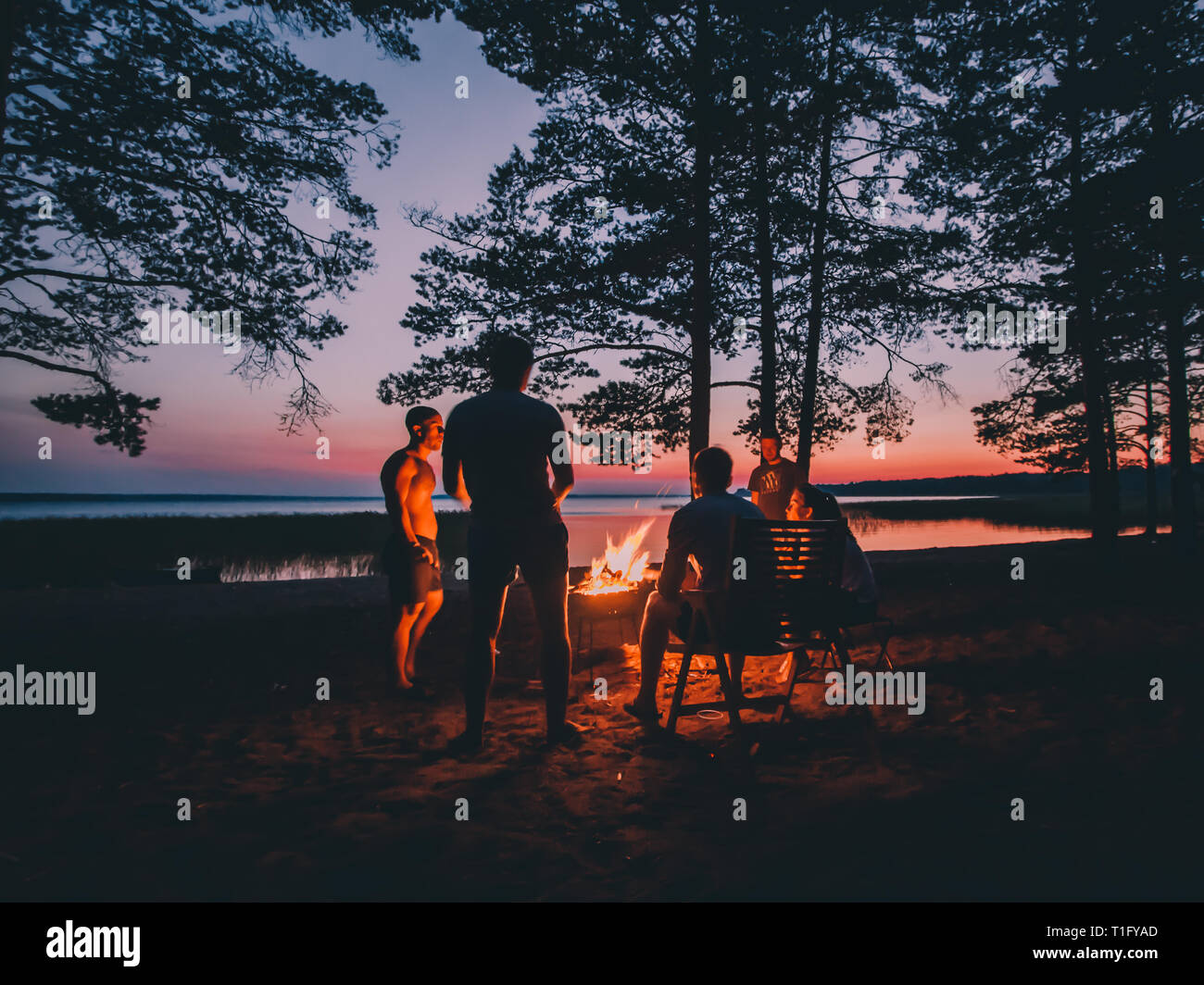 People sitting around campfire night hi-res stock photography and ...