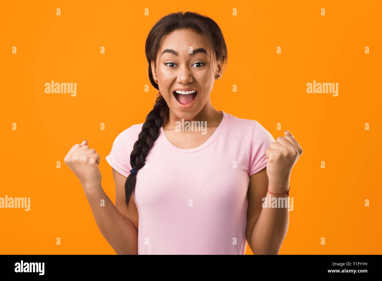 Excited student celebrating success over orange background Stock Photo ...