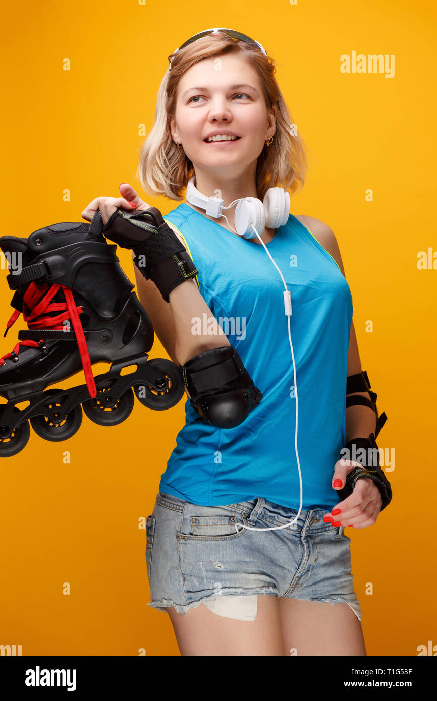 Athletic girl with roller skates on shoulder in studio Stock Photo - Alamy