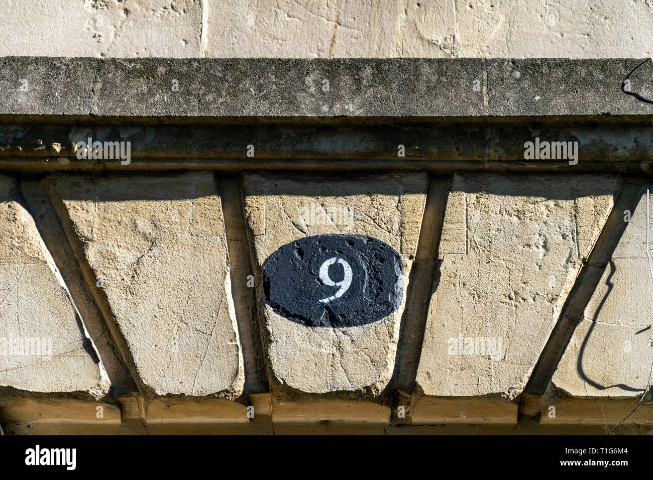 House number nine painted on the stone above a doorway with chamfered ...