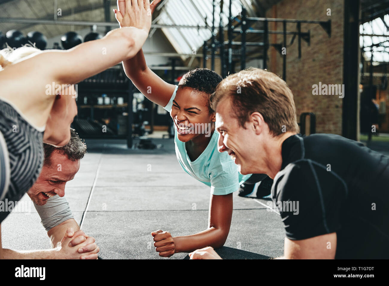 Two laughing young women in sportswear high fiving each other while ...