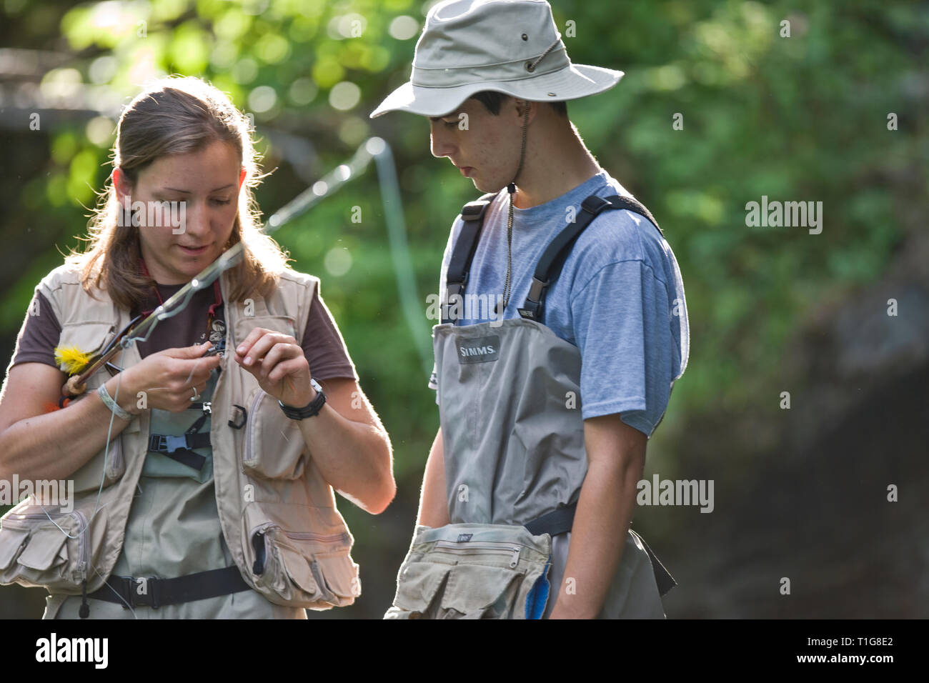 Instructor teaching young man to fish Stock Photo - Alamy