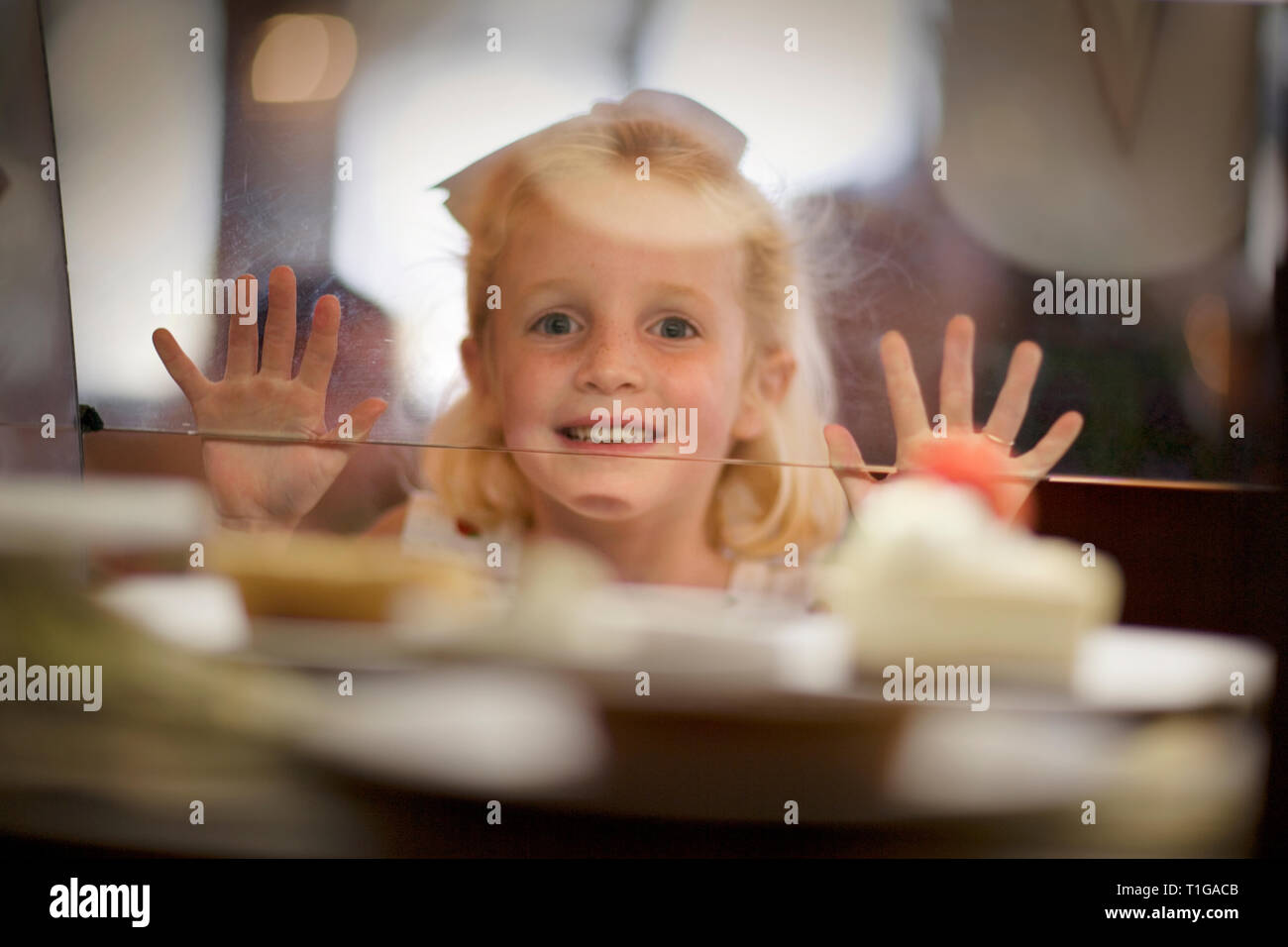 Portrait of a young girl looking through a food cabinet Stock Photo - Alamy