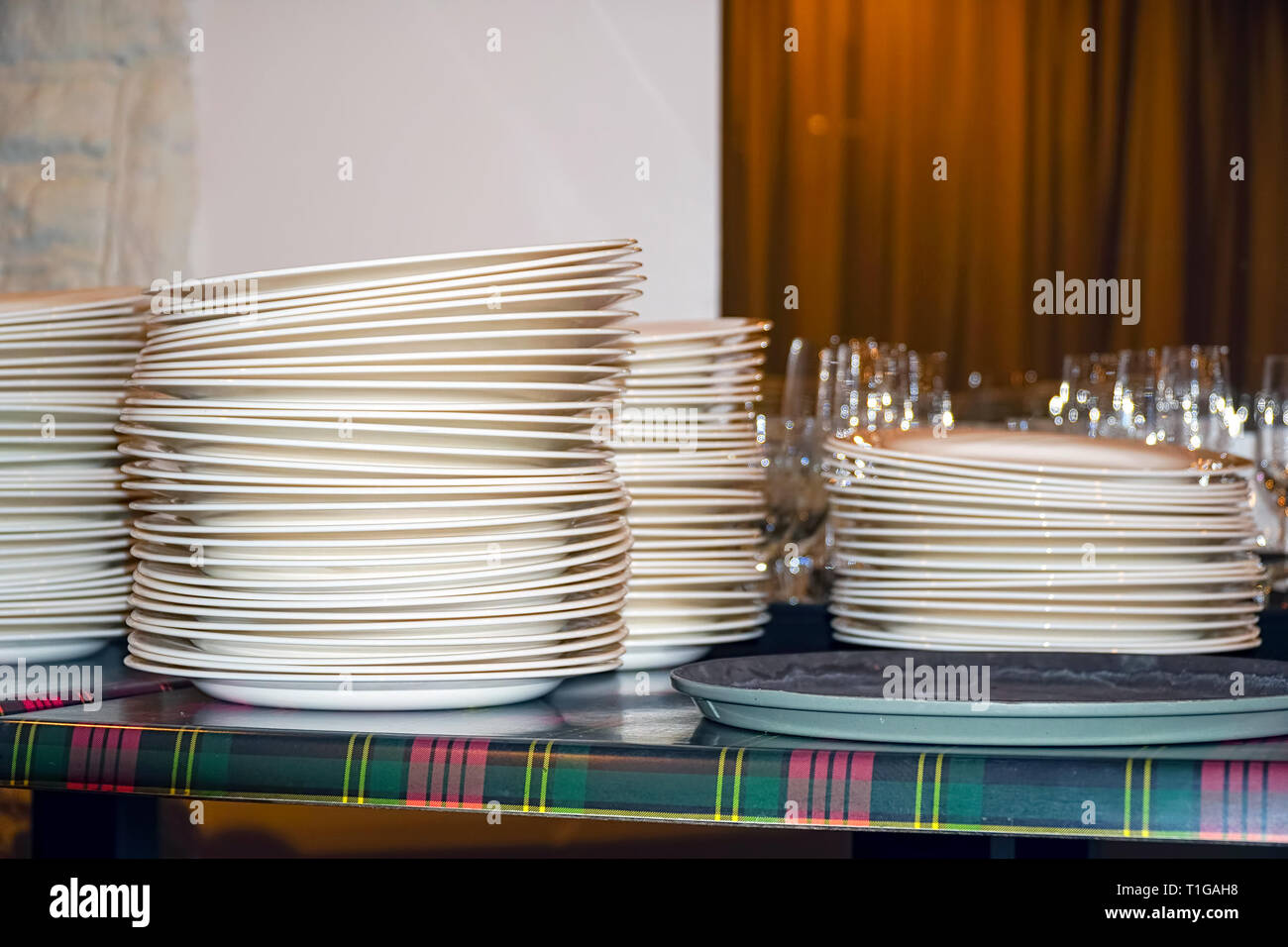 Clean white plates stacked on table Stock Photo - Alamy