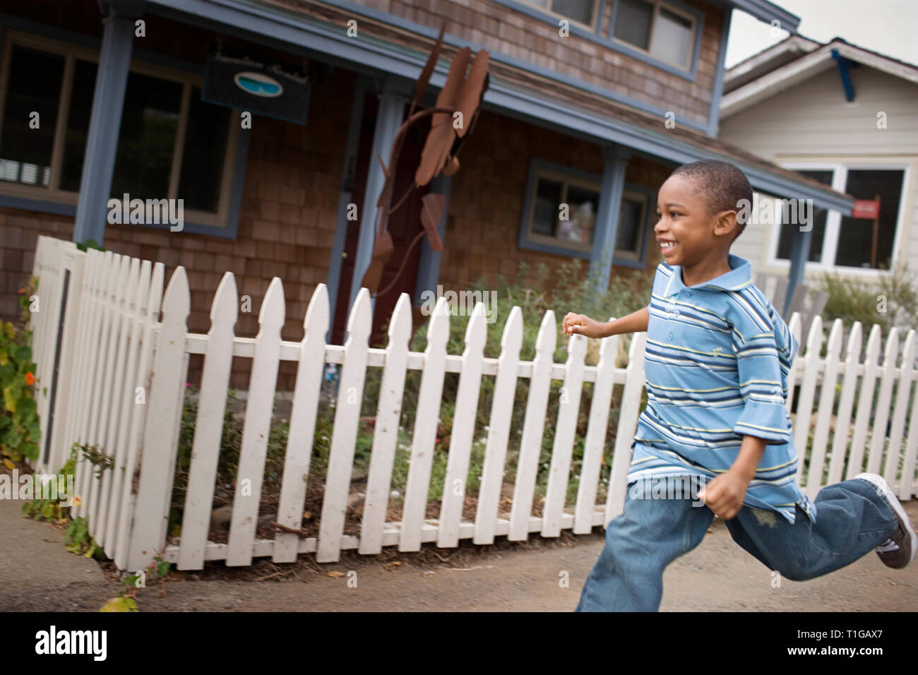 Happy young boy running down a suburban street Stock Photo - Alamy