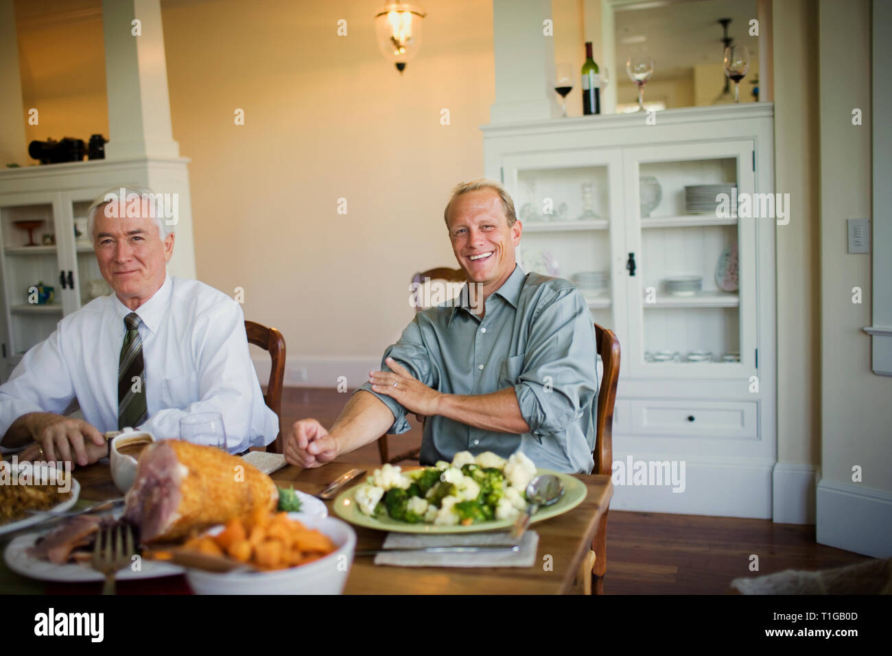 Portrait of two men sitting at a dining table for dinner Stock Photo ...