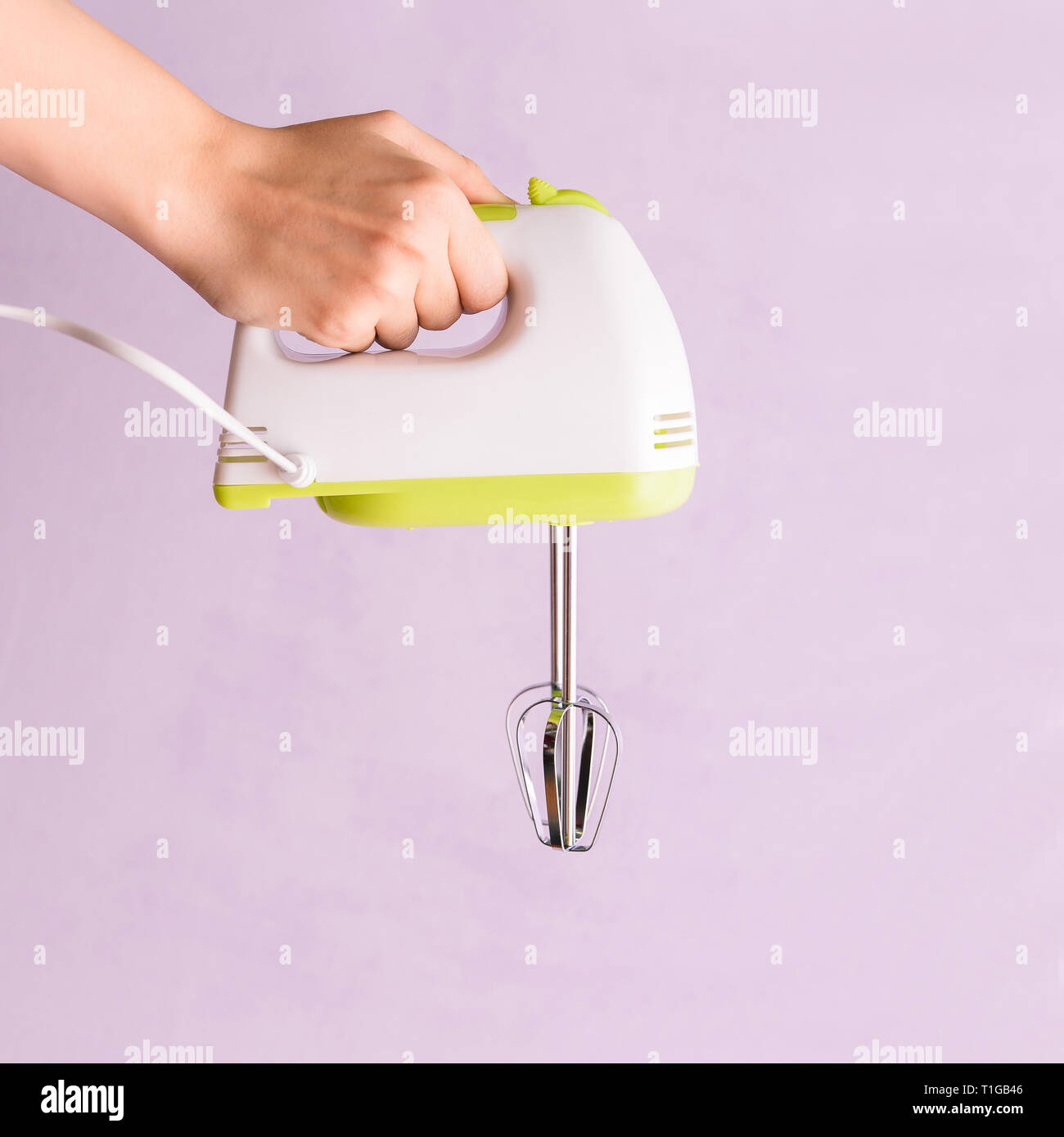 Woman housewife holds in her hand a kitchen mixer. Electrical appliance ...