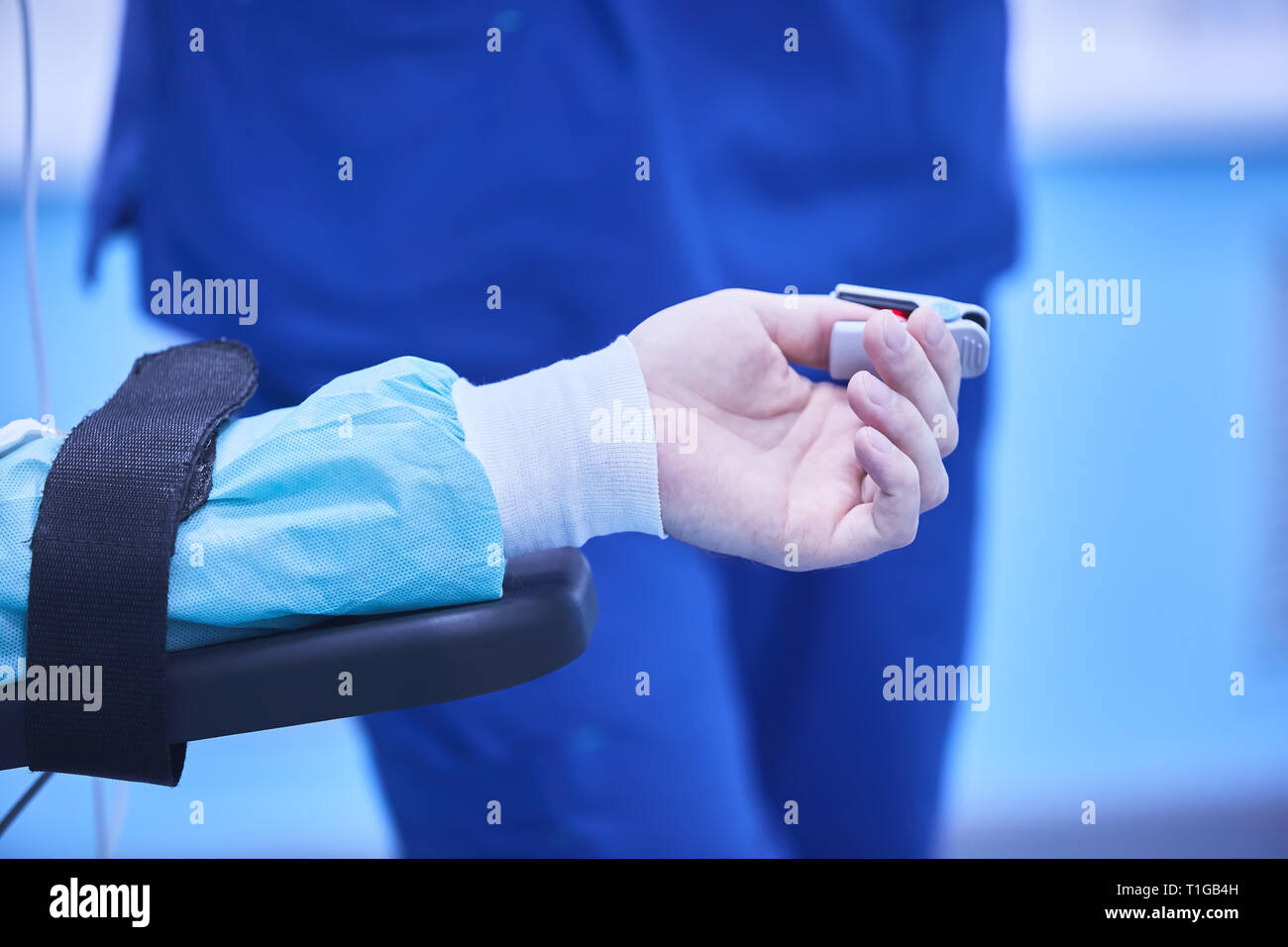 pulse oximeter on finger of patient during surgery. male patient lying ...