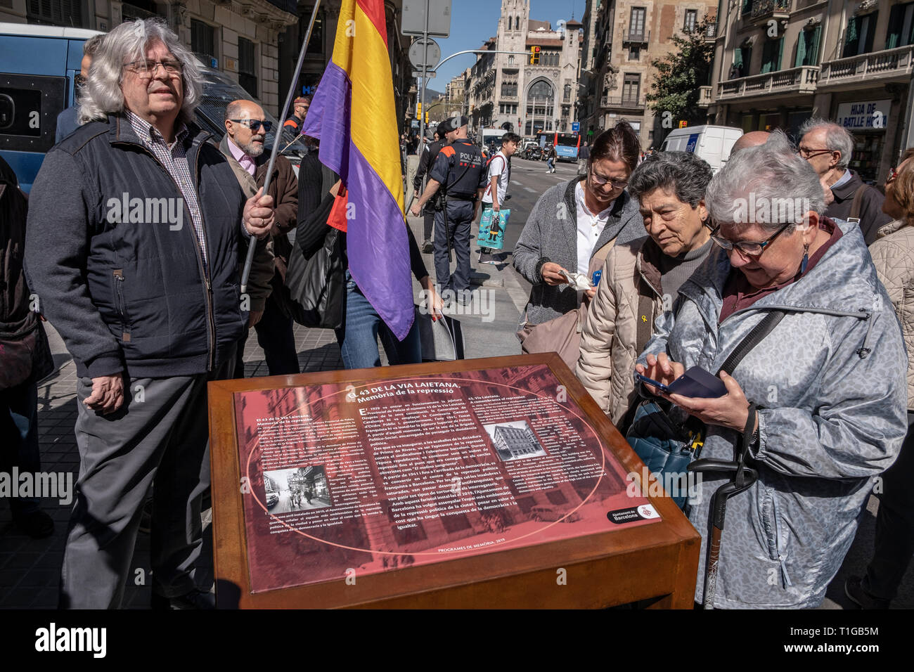 Several participants are seen standing next to a plaque in homage to ...
