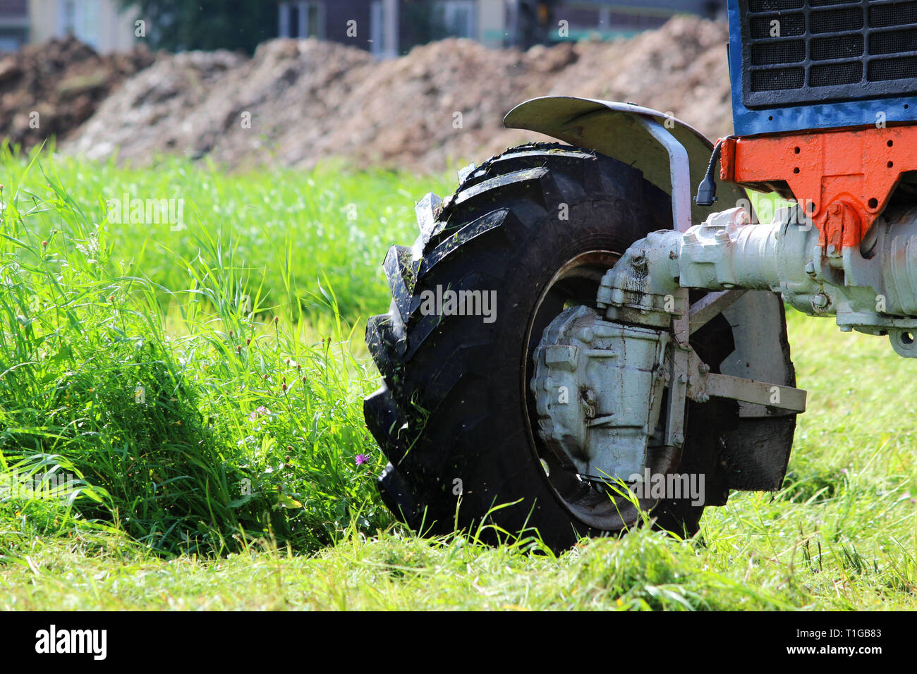 tractor that mows grass on urban lawns. the tractor mows the grass with ...