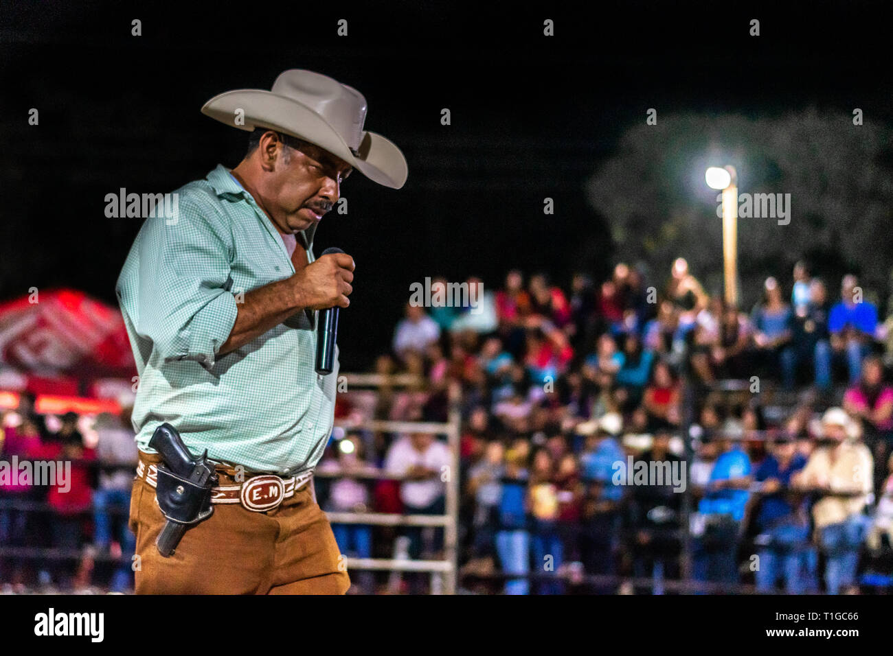latin man with gun singing in Guatemalan rodeo Stock Photo - Alamy