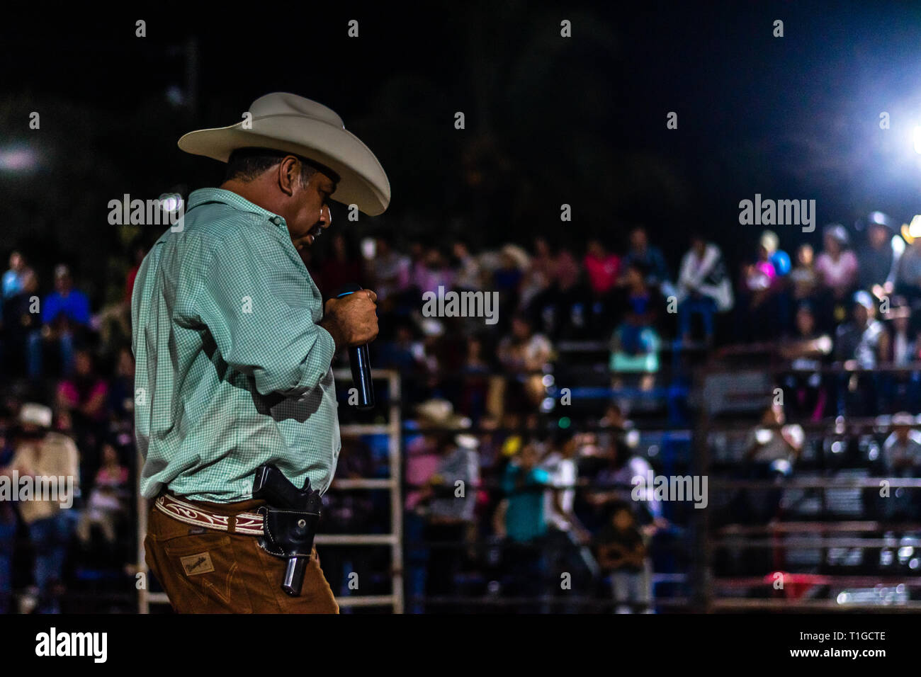 latin man with gun singing in Guatemalan rodeo Stock Photo - Alamy