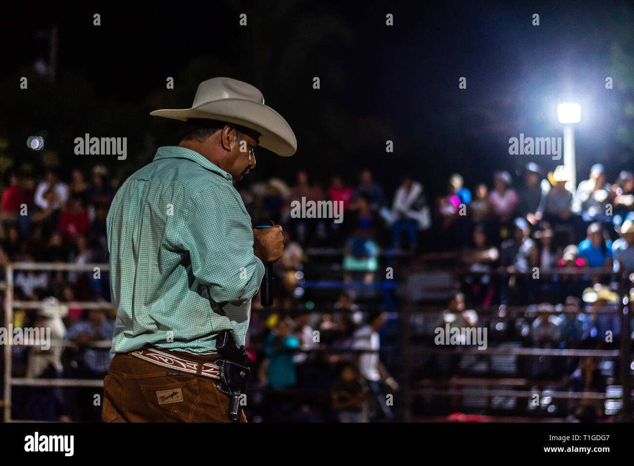 latin man with gun singing in Guatemalan rodeo Stock Photo - Alamy