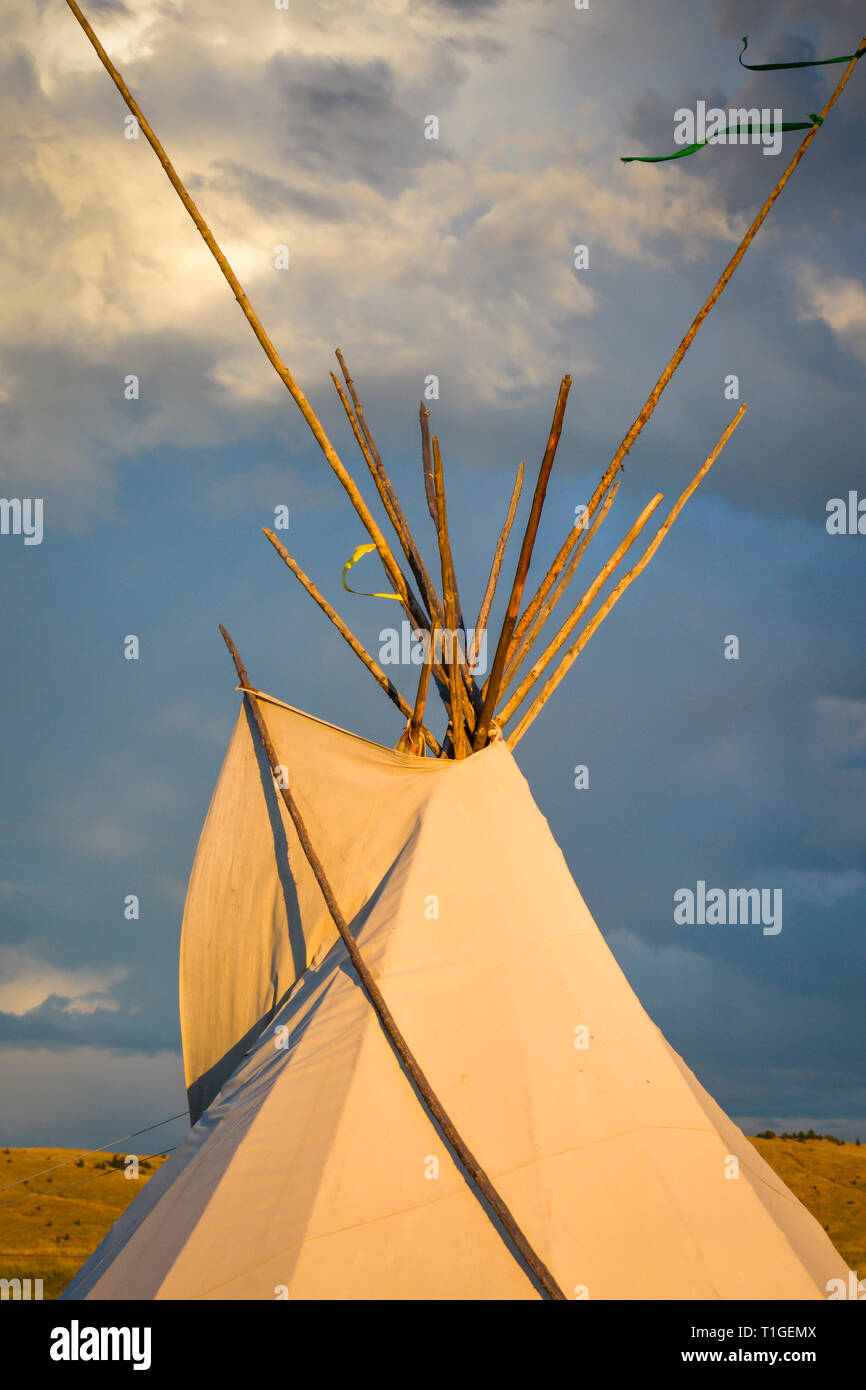 A close up at sunset of the top half of a tipi with dramatic sky in the ...