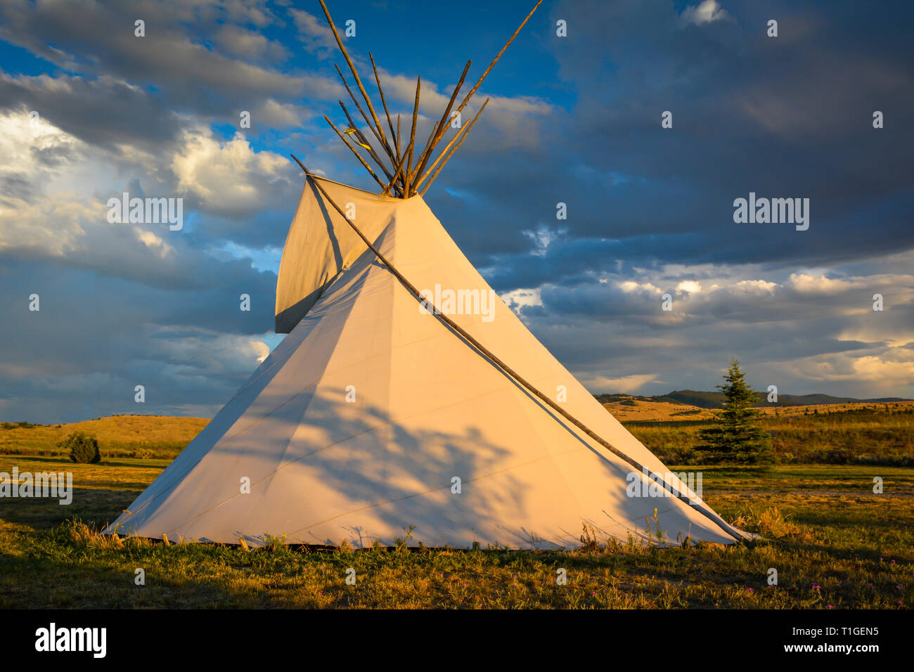 A tipi with dramatic sky in the Western plains at sunset in the USA ...