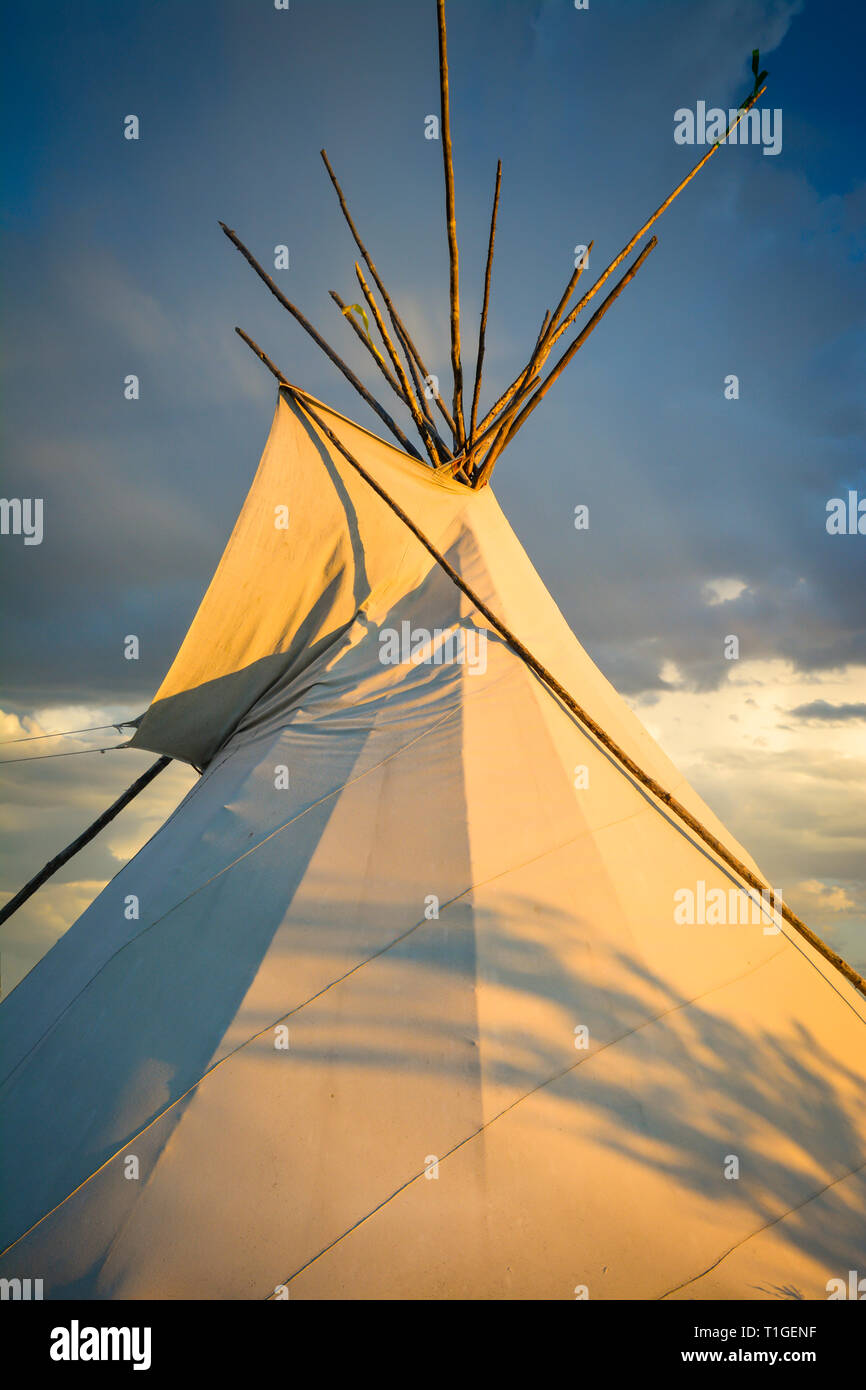 A cropped view of a tipi with dramatic sky in the Western plains at ...