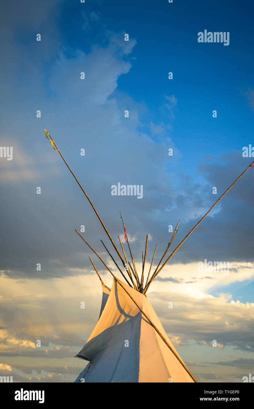 A cropped view of a tipi with dramatic sky in the Western plains at ...