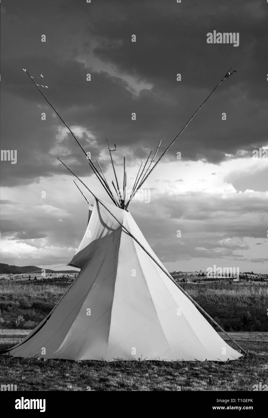 View of a tipi with dramatic sky in the Western plains at sunset in the ...
