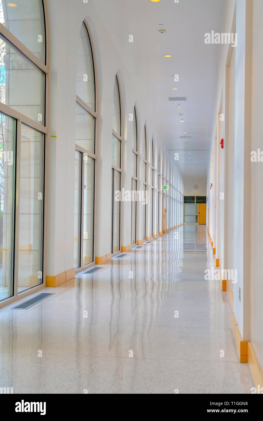 Hallway of a modern building with arched windows. Long hallway inside a ...