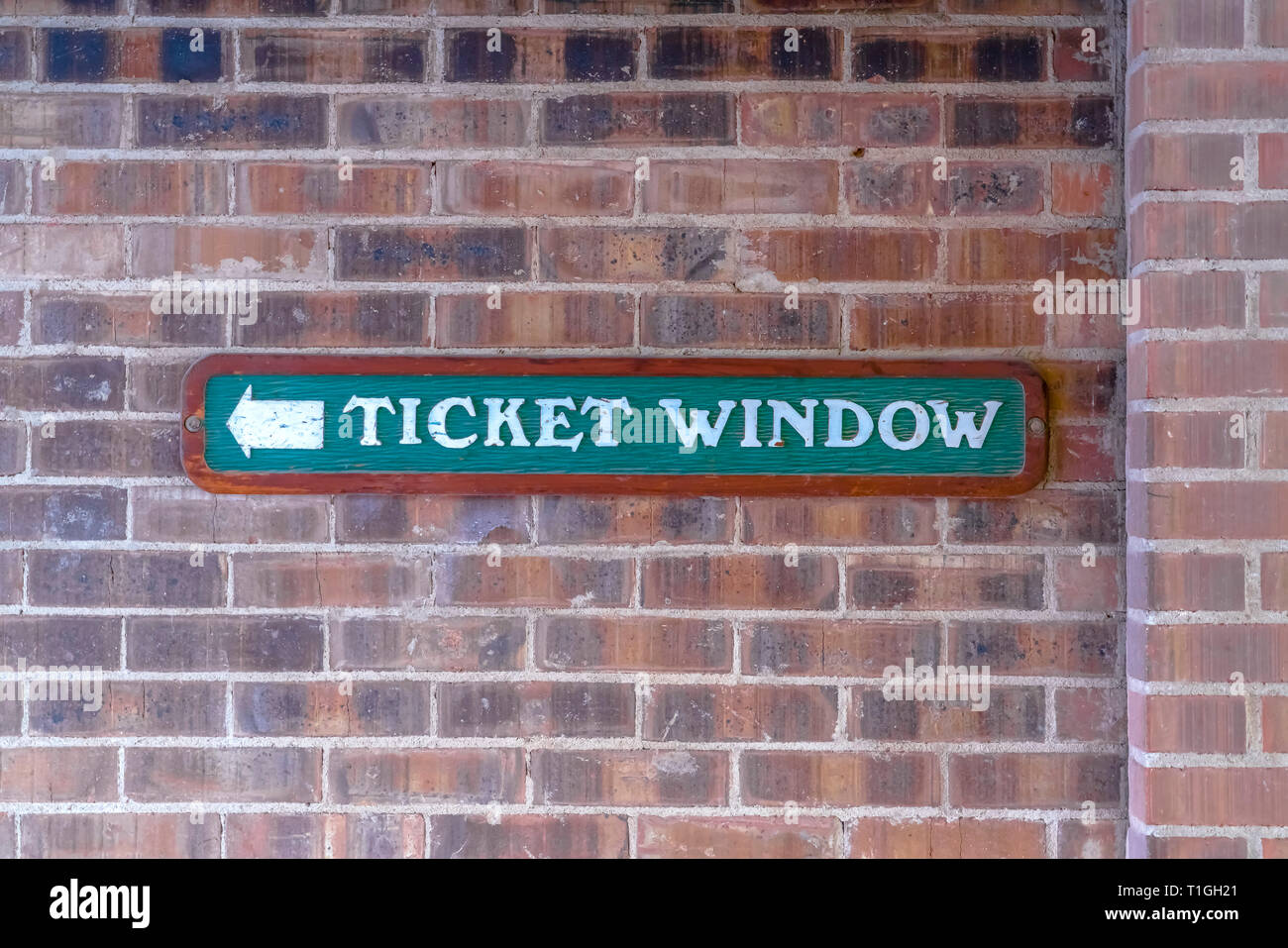 Ticket Window sign against a brick wall. A Ticket Window sign with an ...