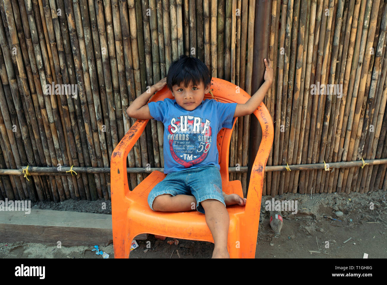 Native kuna boy sitting on plastic chair in Carti island, one of the ...