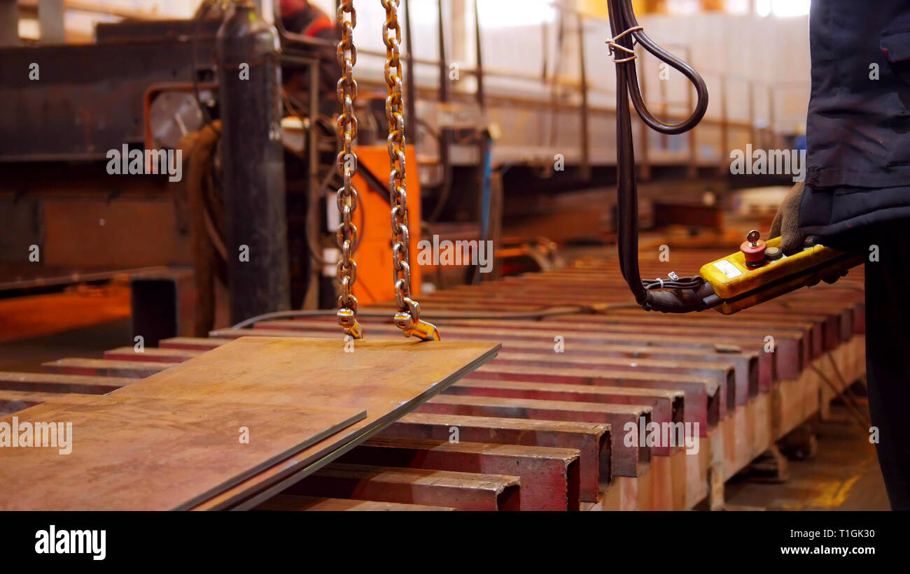 A man working with a lifting machine on the plant. Holding a control ...