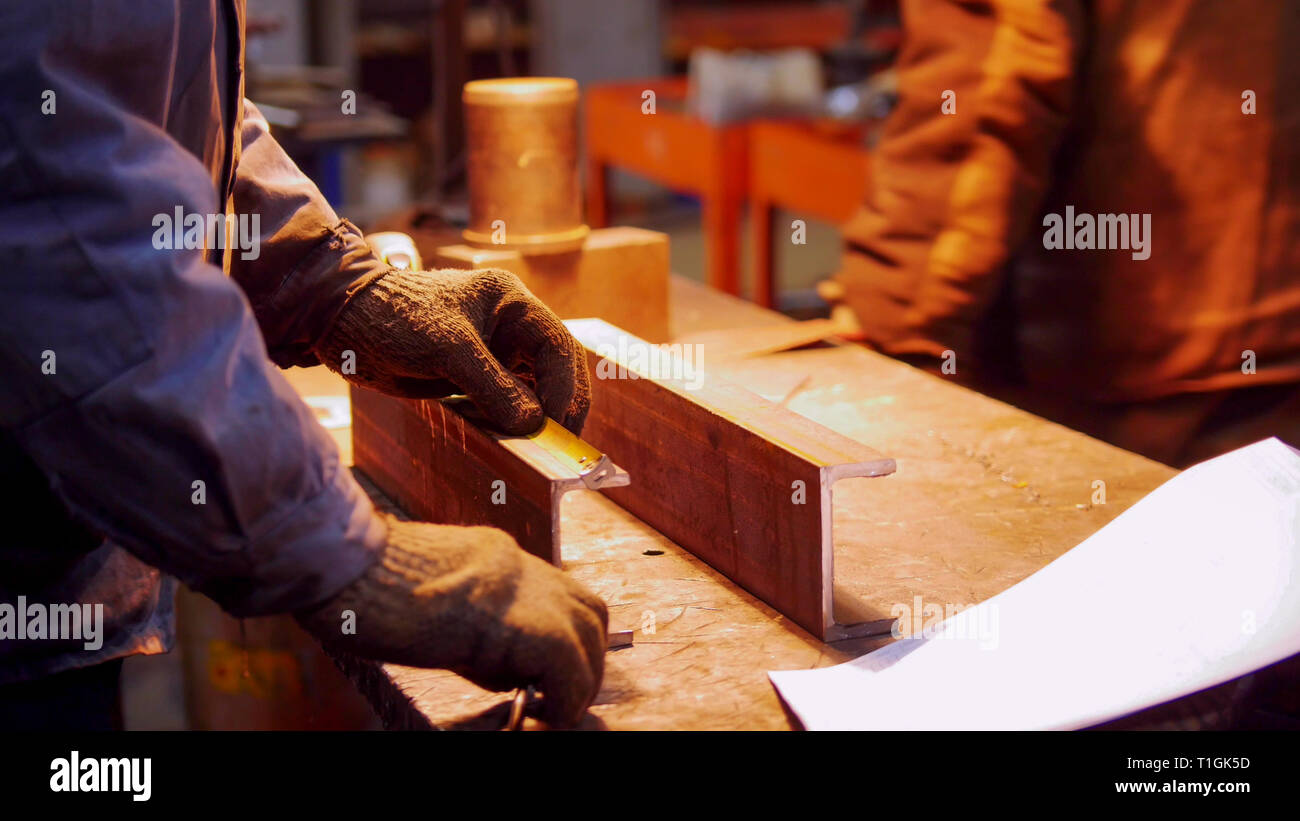 Construction plant. A man working with a small iron detail Stock Photo ...