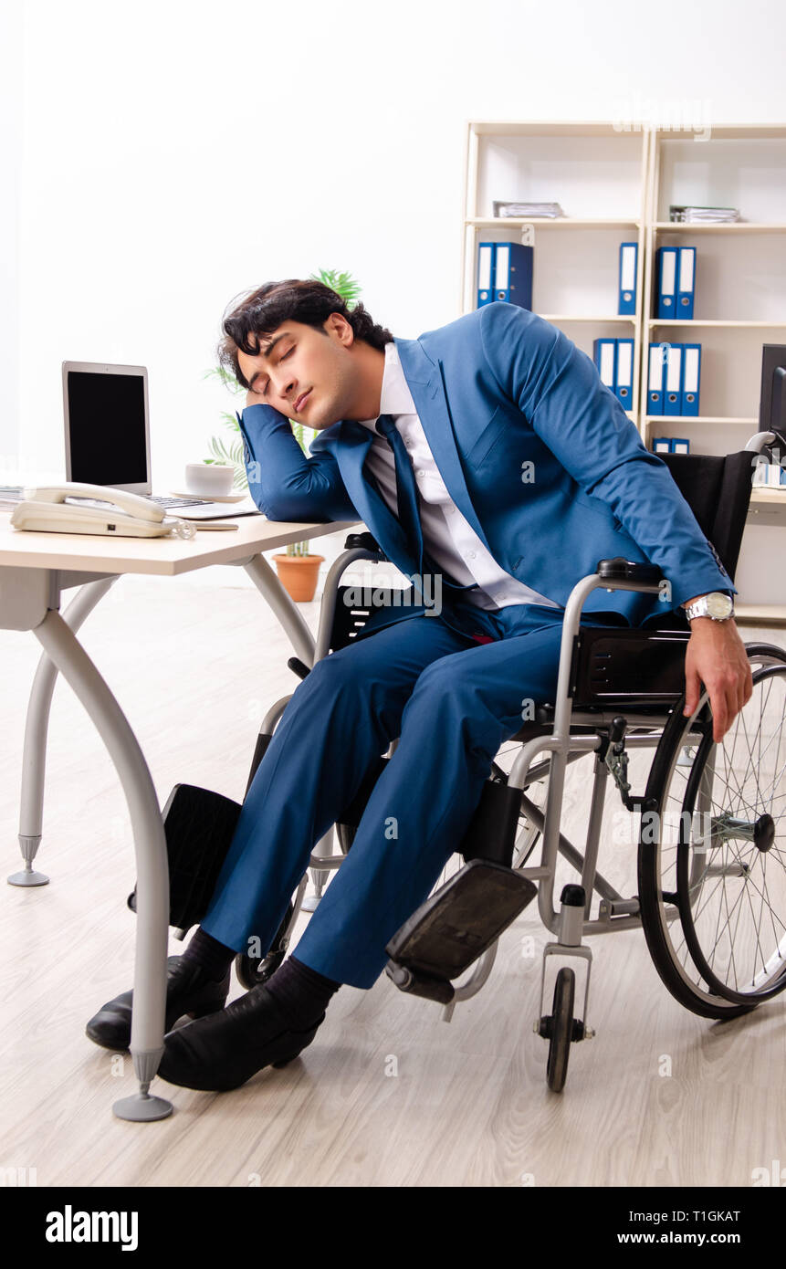 Male employee in wheelchair working at the office Stock Photo - Alamy