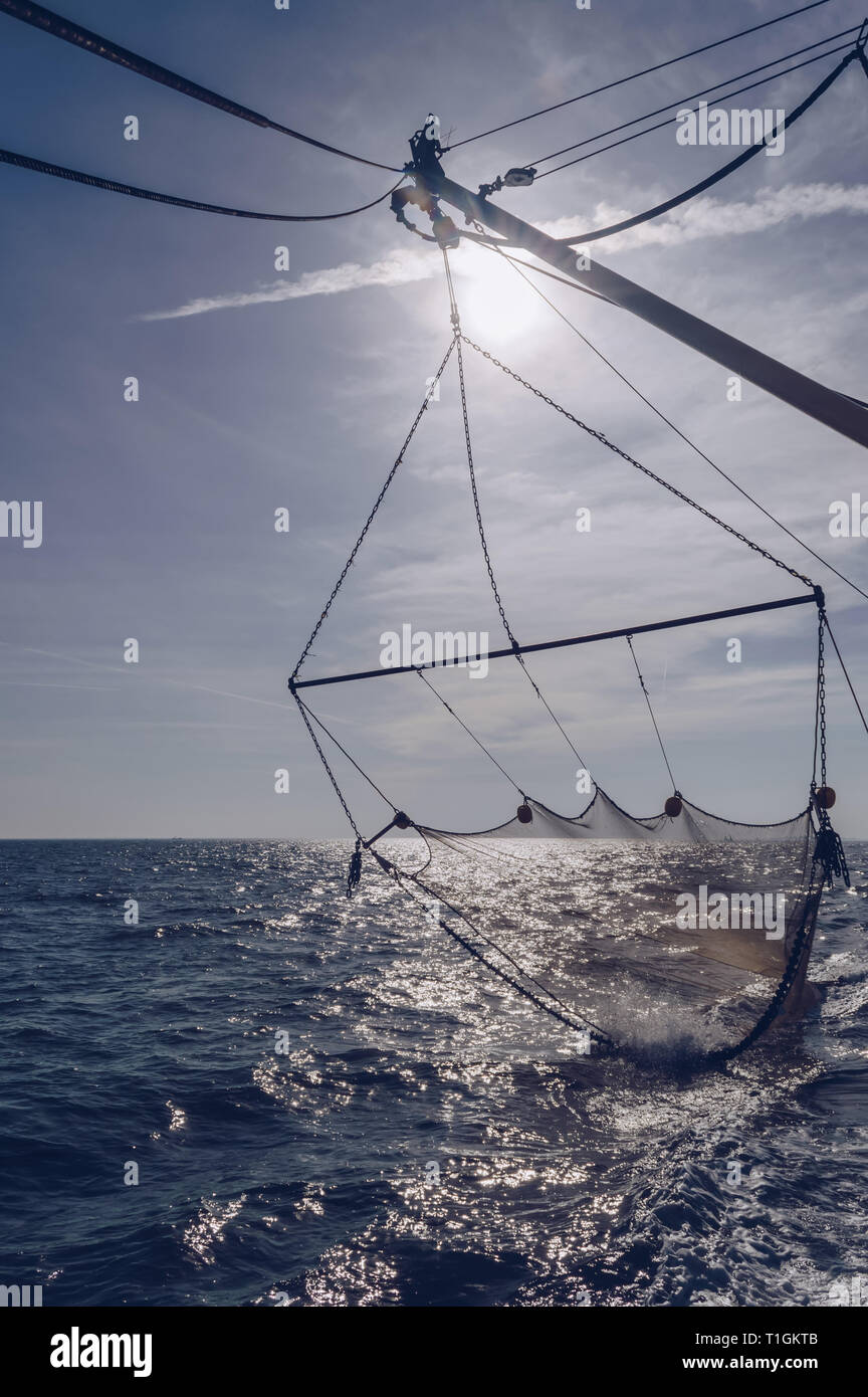 straightened trawler net with shining sun and blue sky on background ...