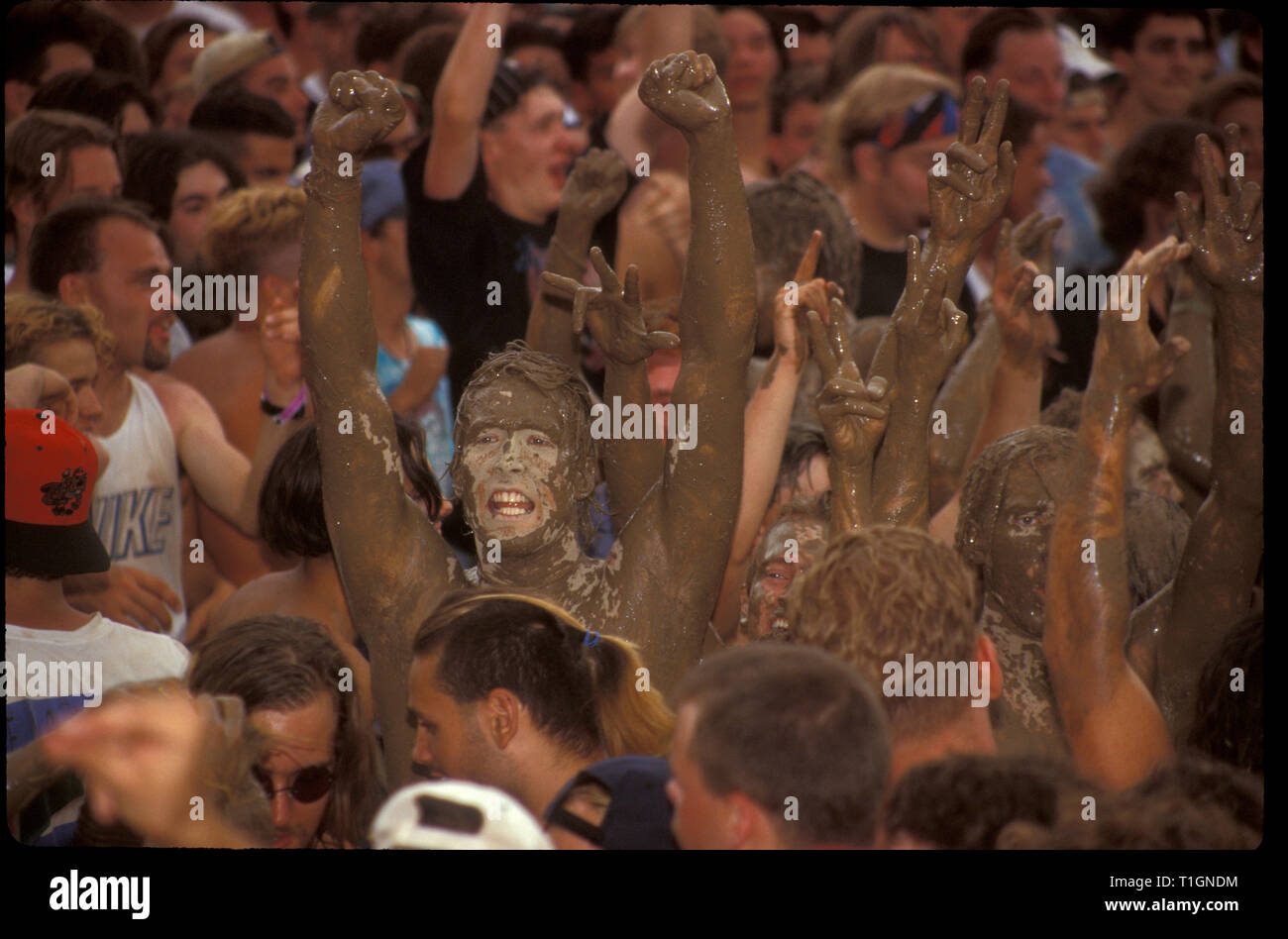 Mud covered concert fans are shown having fun in the crowd during ...