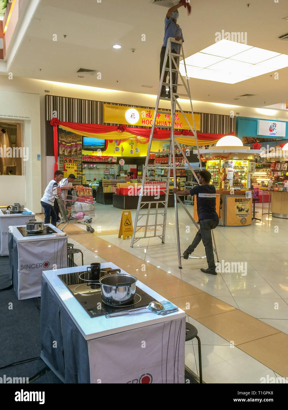 Man up a ladder in a shopping mall in Johor, Malaysia Stock Photo - Alamy