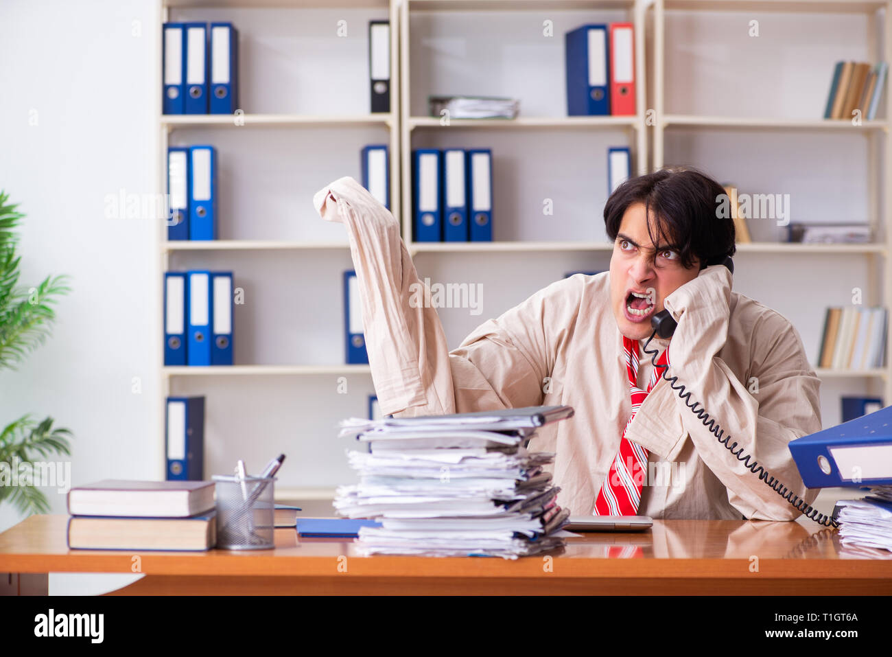 Crazy young man in straitjacket at the office Stock Photo - Alamy