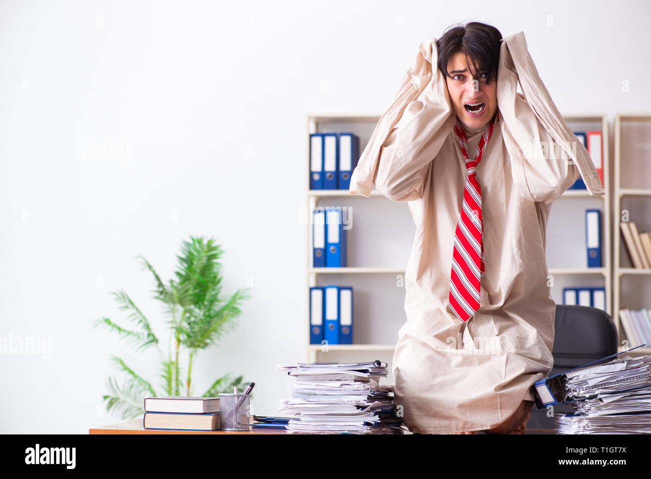 Crazy young man in straitjacket at the office Stock Photo - Alamy