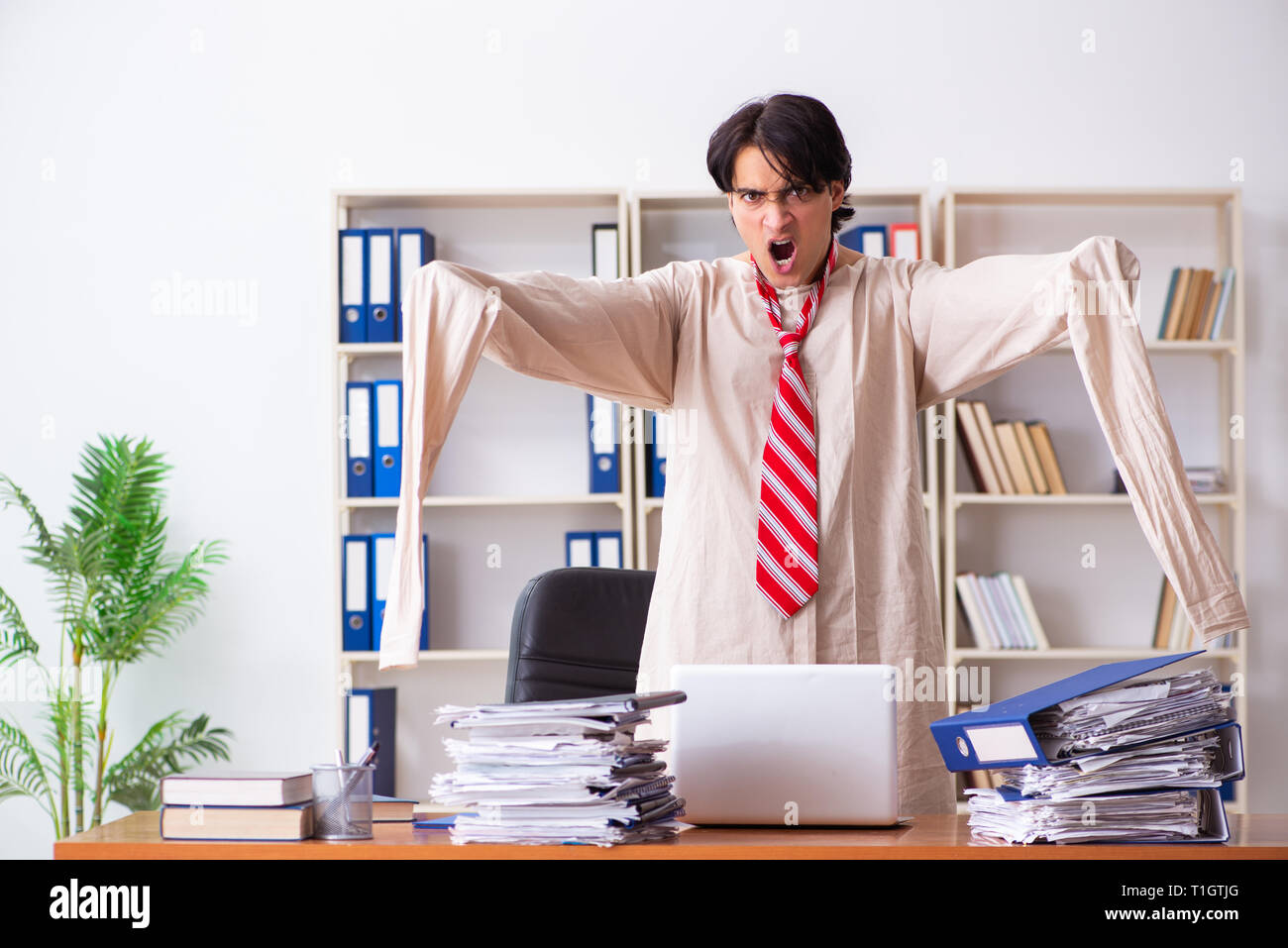 Crazy young man in straitjacket at the office Stock Photo - Alamy