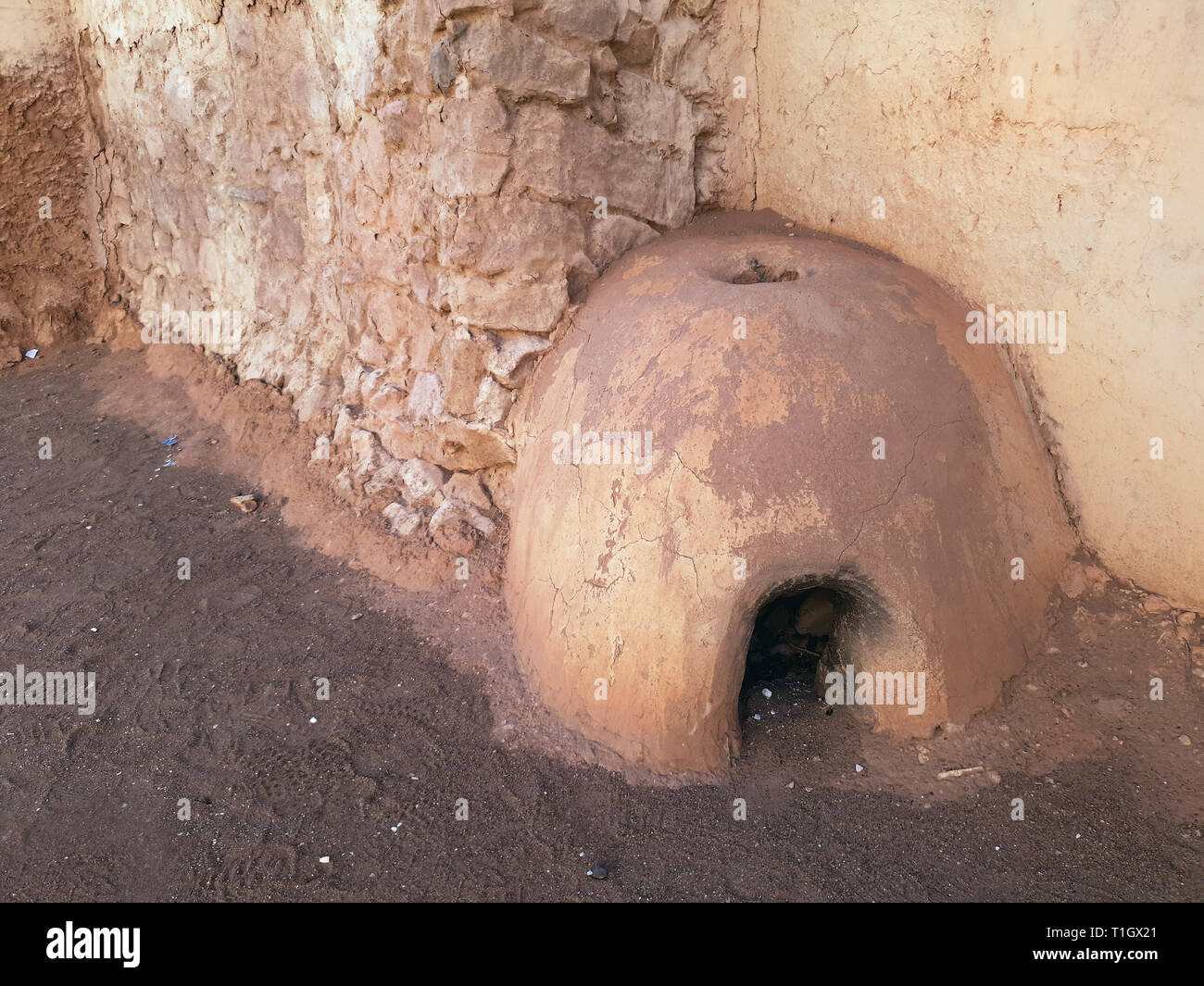 Ancient clay stove near the wall of beige color on black earth Stock ...