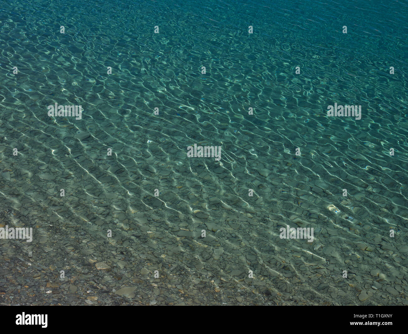 Transparent aquamarine water surface with slight ripple of waves on the ...