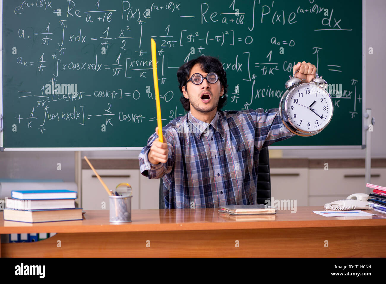 Funny male math teacher in the classroom Stock Photo - Alamy