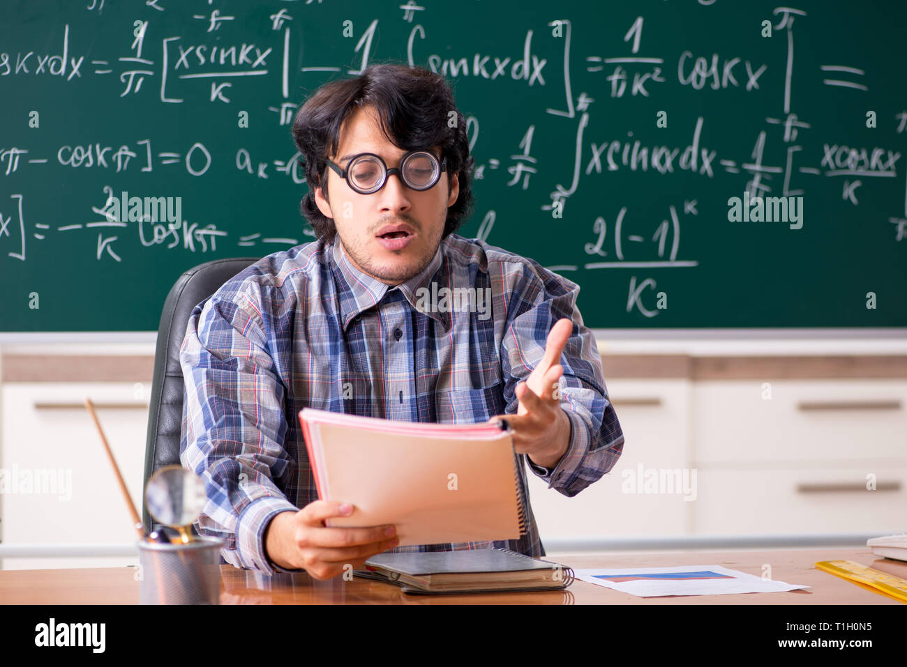 Funny male math teacher in the classroom Stock Photo - Alamy