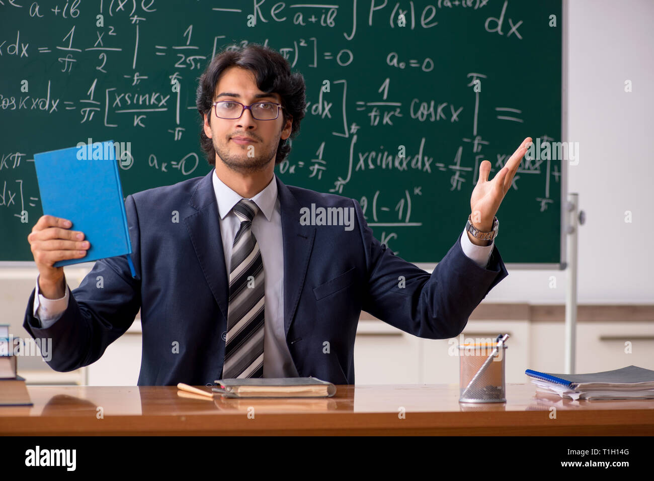 Young male math teacher in classroom Stock Photo - Alamy