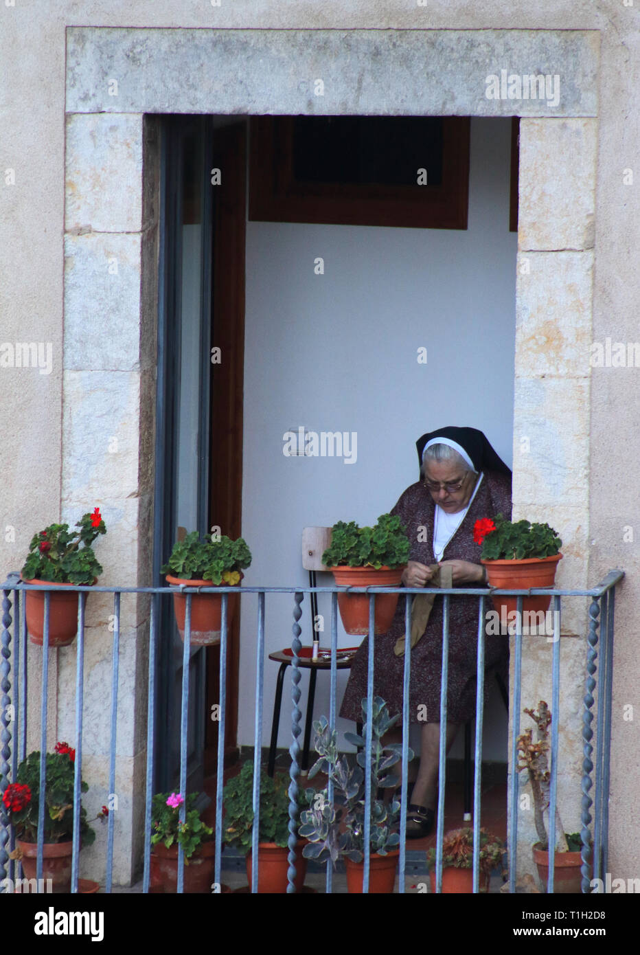 Nun in the window of a house near Girona cathedral Stock Photo - Alamy